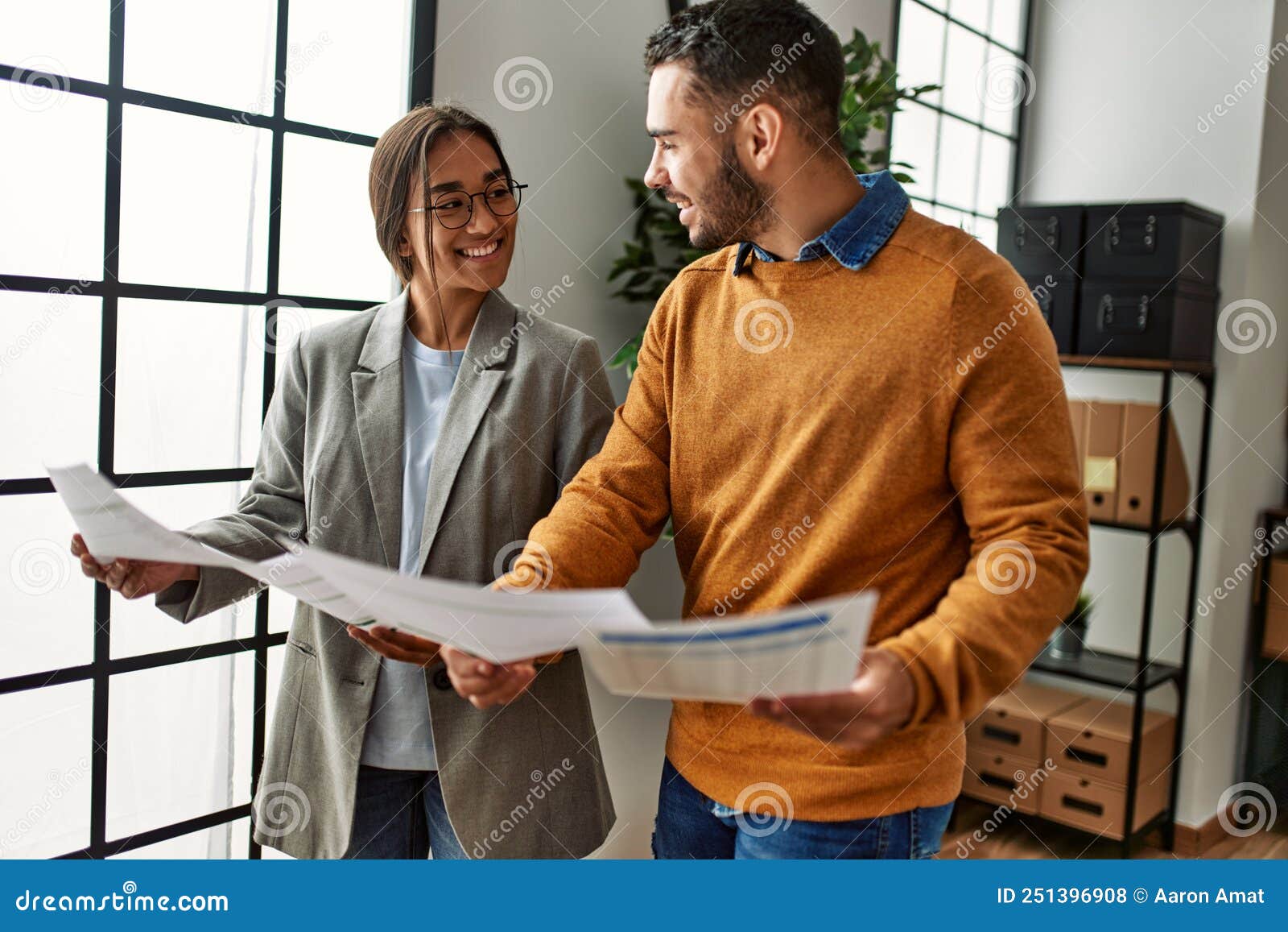 Two Business Workers Smiling Happy Reading Paperwork Standing at the ...