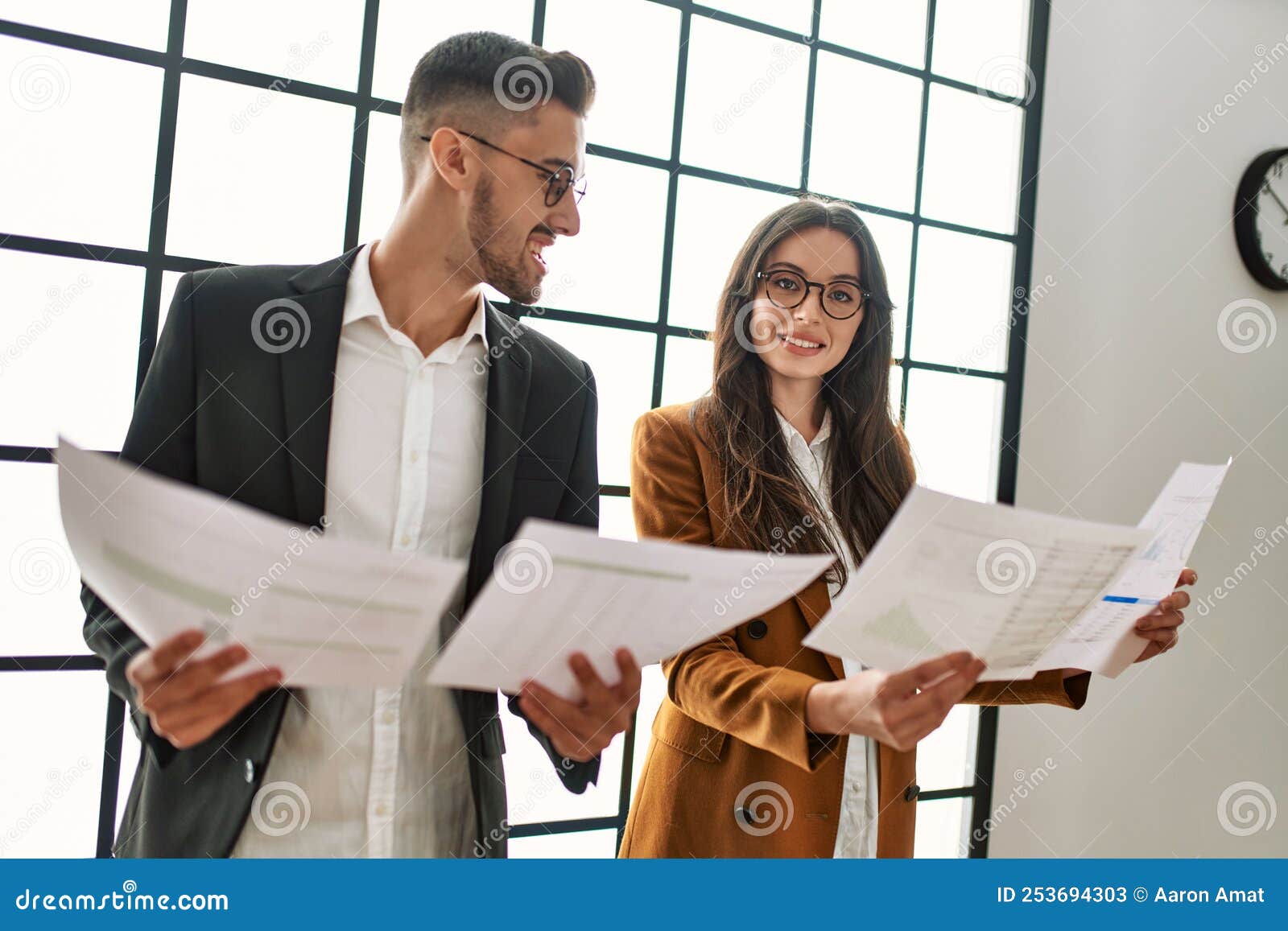 Two Business Workers Smiling Happy Reading Paperwork Standing at the ...