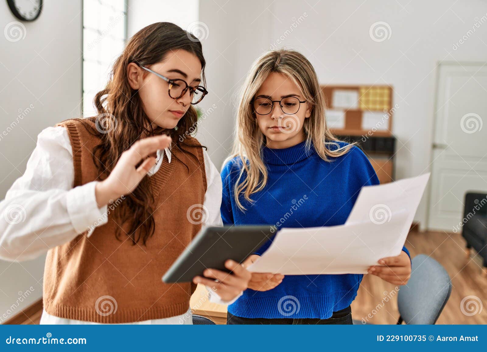 Two Business Workers Woman Reading Paperwork Using Touchpad at the ...