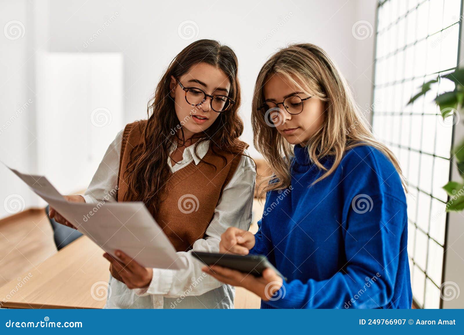 Two Business Workers Woman Reading Paperwork Using Touchpad at the ...