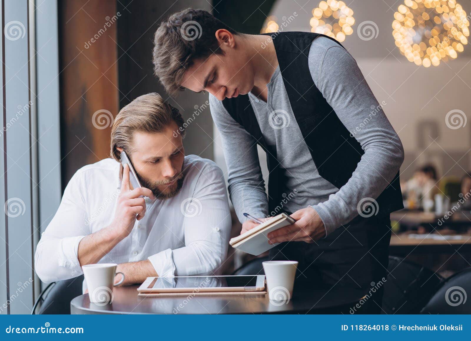Two Businessmen Discussing Work and Using Tablet Stock Photo - Image of ...
