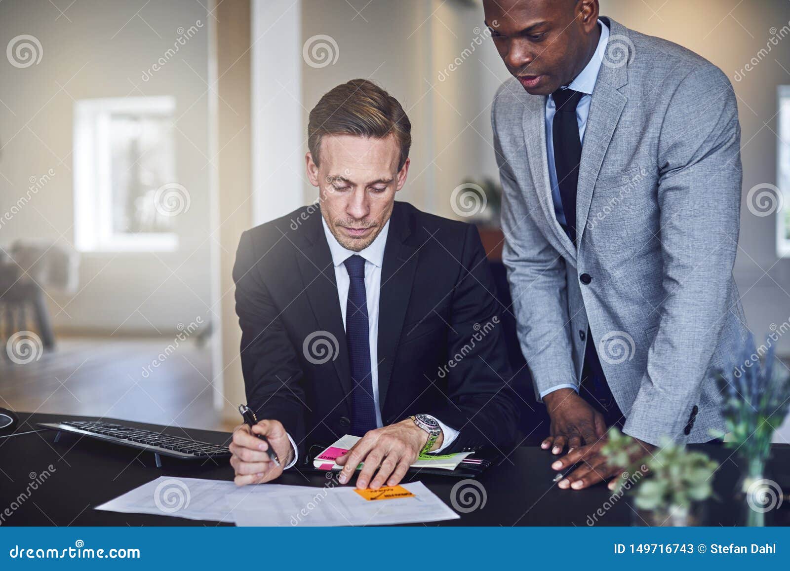 Two Businessmen Going Over Paperwork Together in an Office Stock Image ...