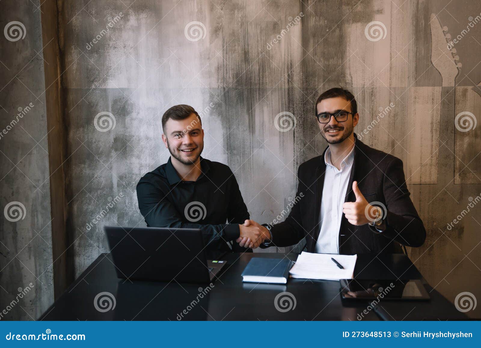 Two Businessmen in an Office Smiling at the Camera while Working ...
