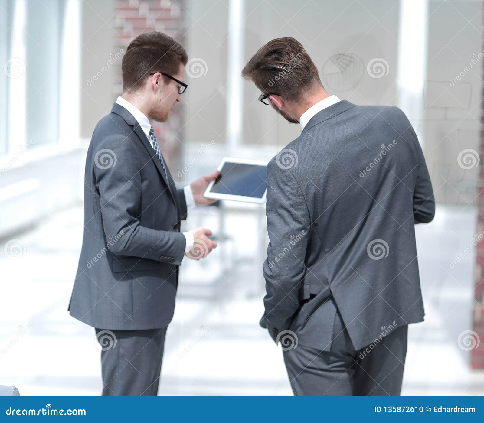 Two Businessmen Reading a Message on a Digital Tablet Stock Photo ...