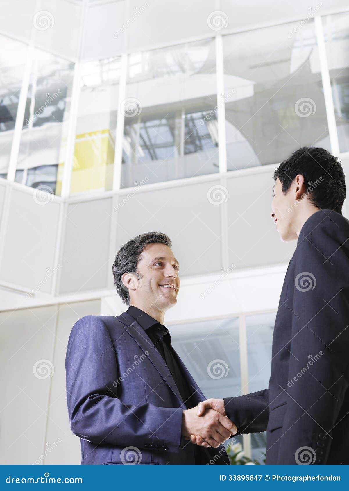Two Businessmen Shaking Hands in Office Stock Image - Image of ...