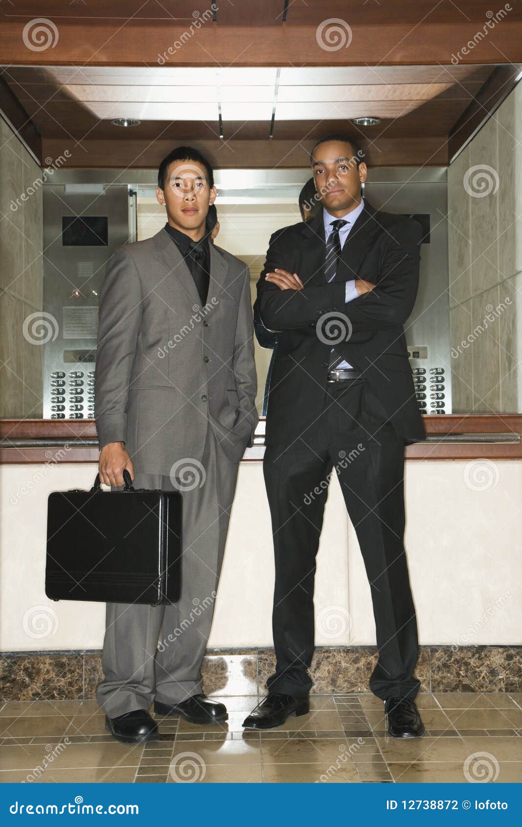 Two Businessmen Standing in Lobby Stock Photo - Image of attractive ...
