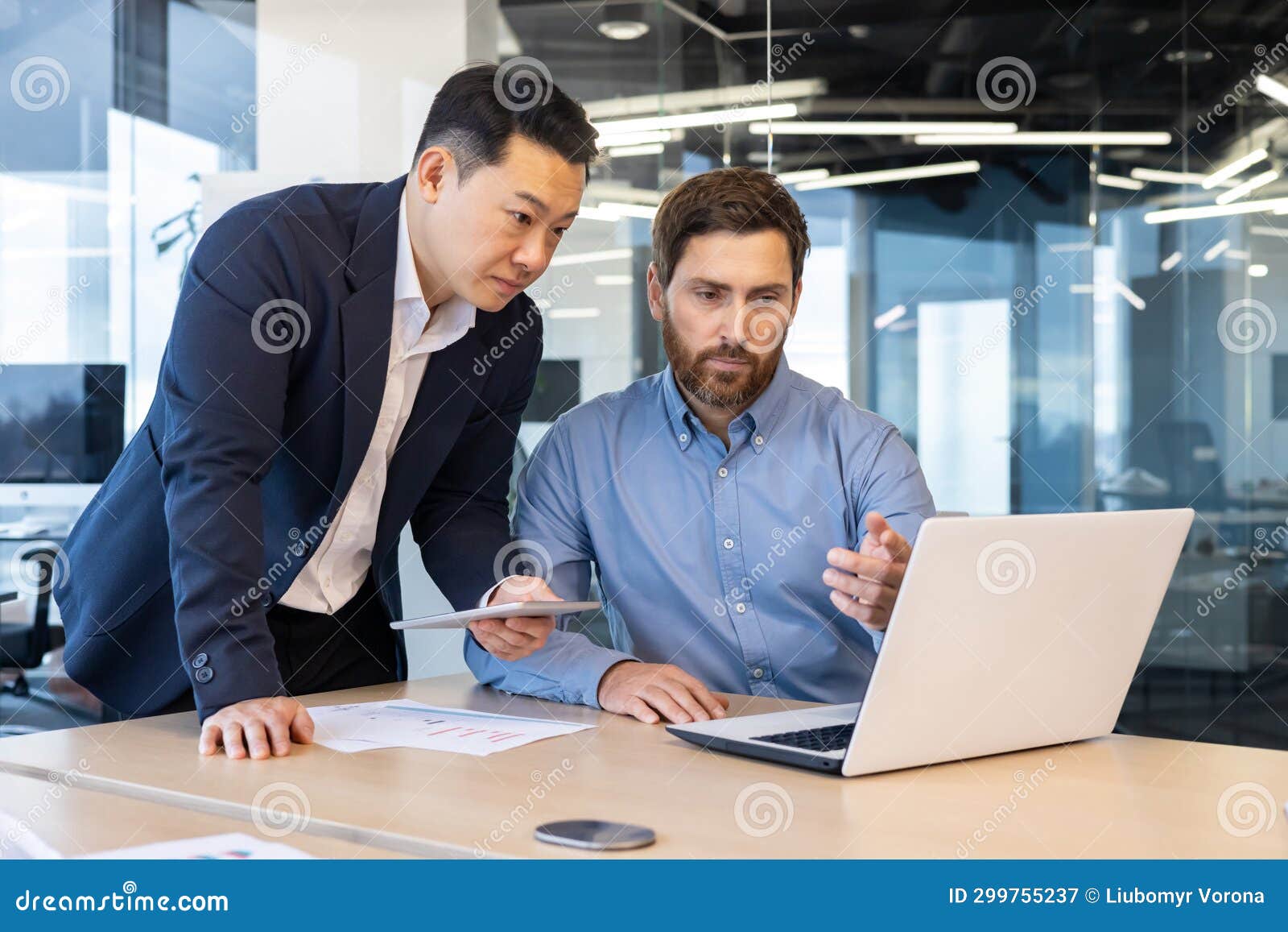 Two Businessmen in Suits Work in the Office, Look at a Laptop, Discuss ...