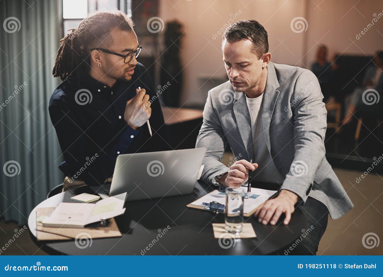 Two Businessmen Working Over a Laptop Together in an Office Stock Photo ...