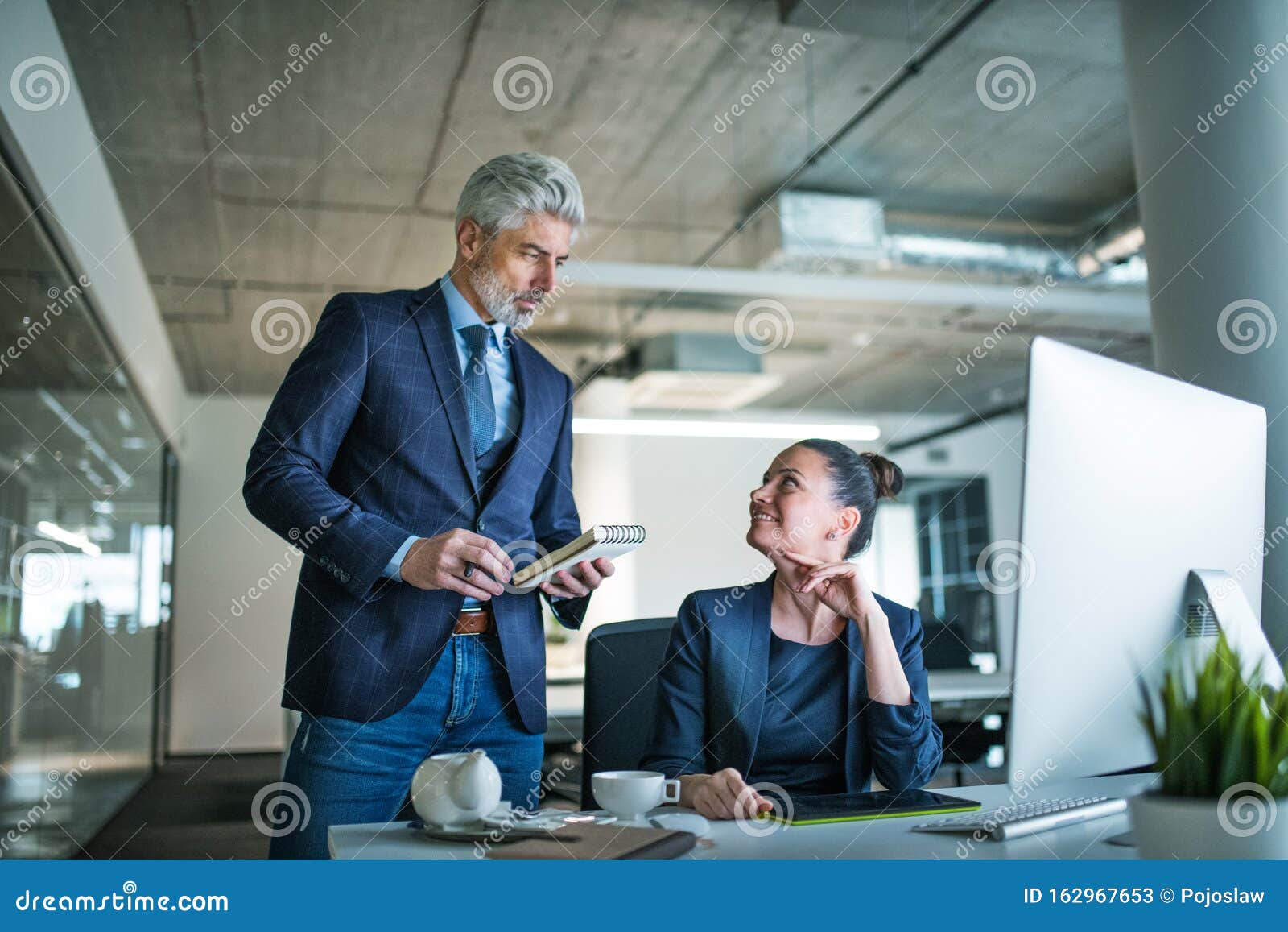Two Businesspeople with Computer Sitting in an Office at Desk. Stock ...