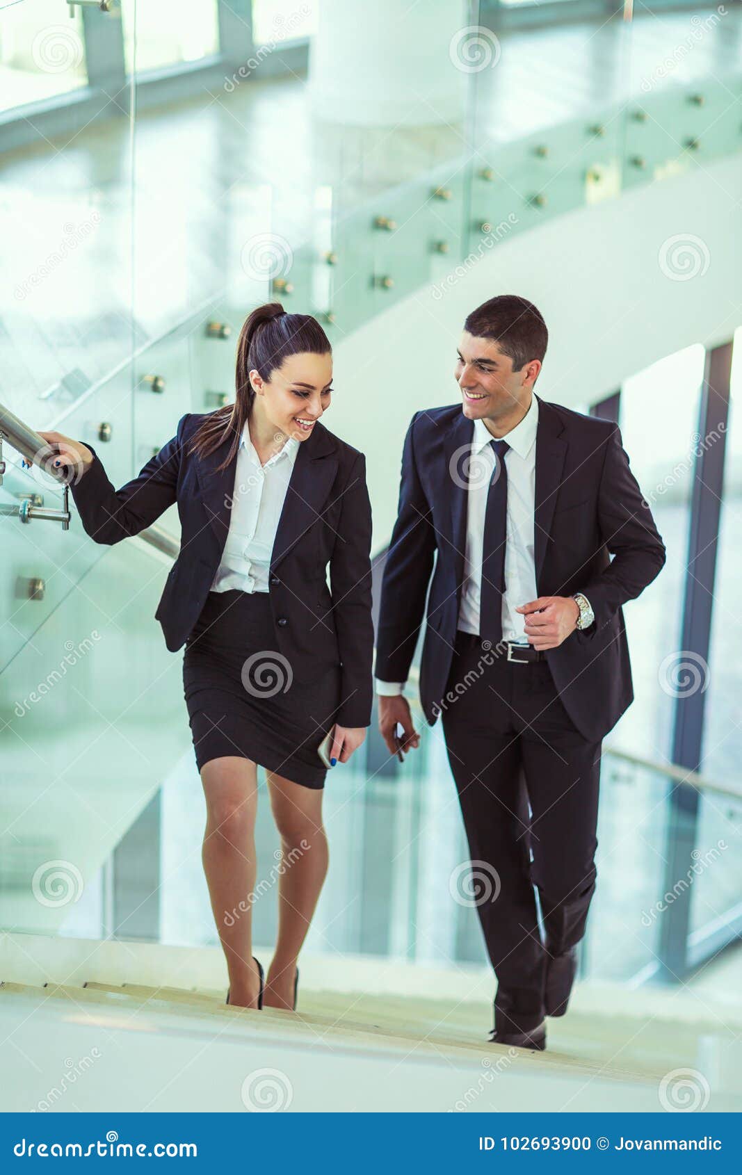Two Businesspeople Talking As they Walk into the Office Stock Photo ...