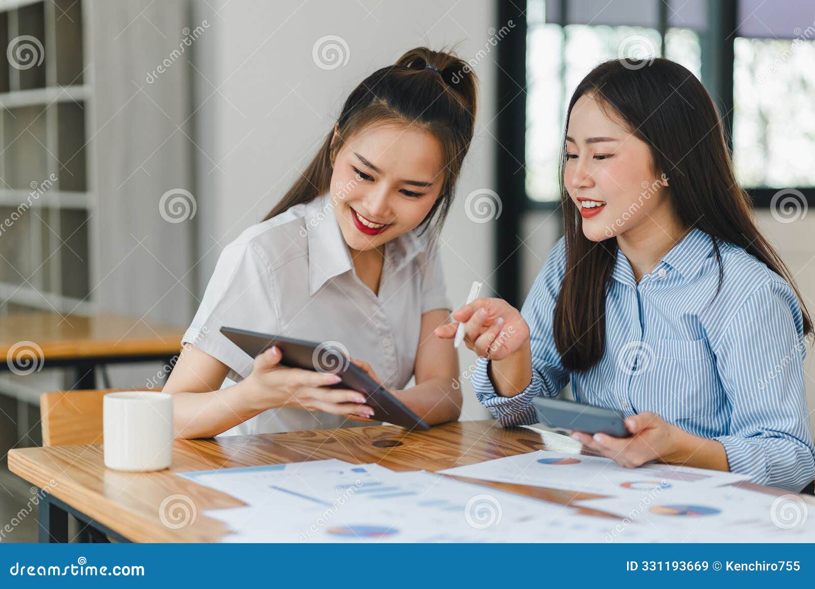 Two Businesswomen Reviewing Data on a Tablet in an Office. Stock Image ...