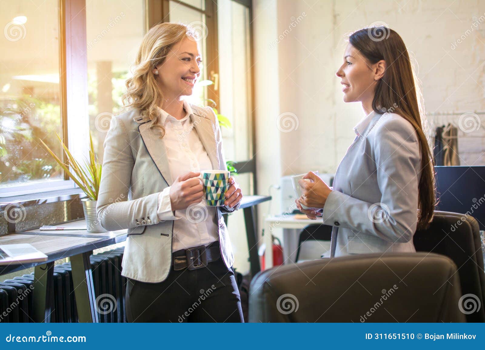 Two Businesswomen Talking during Coffee Break in Office. Stock Photo ...