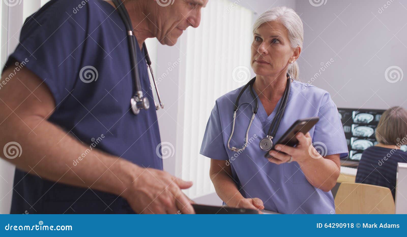 Two Caucasian Mature Doctors or Nurses on Tech Devices Stock Photo ...