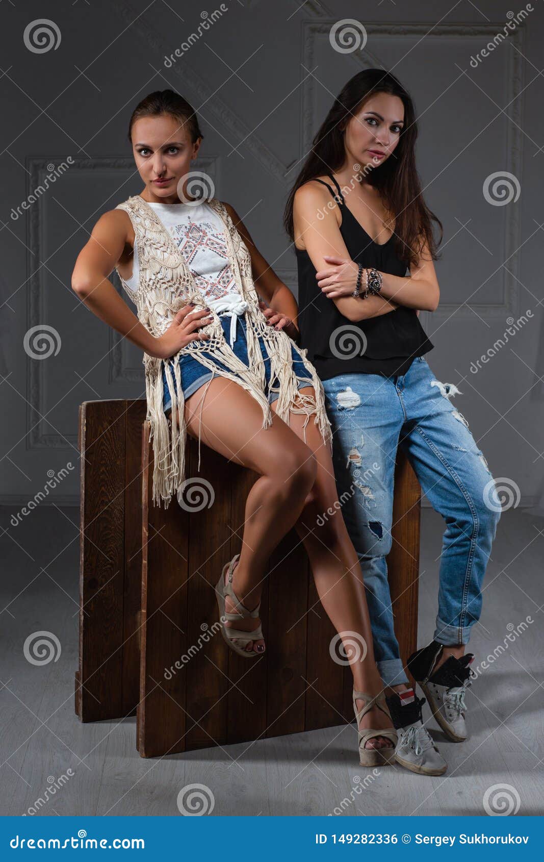 Two Charming Lady Posing in a Studio Stock Photo - Image of jeans, calm ...