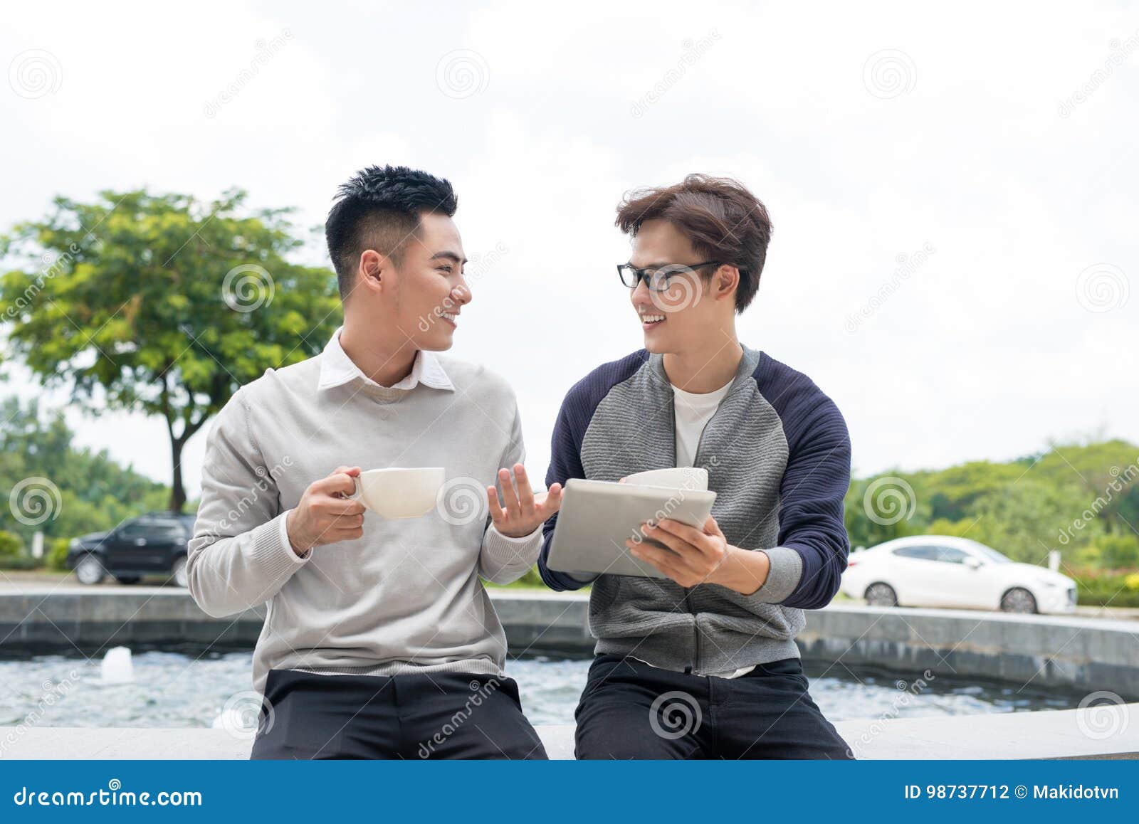 Two Cheerful Asian Business People Discussing with Documents Stock ...