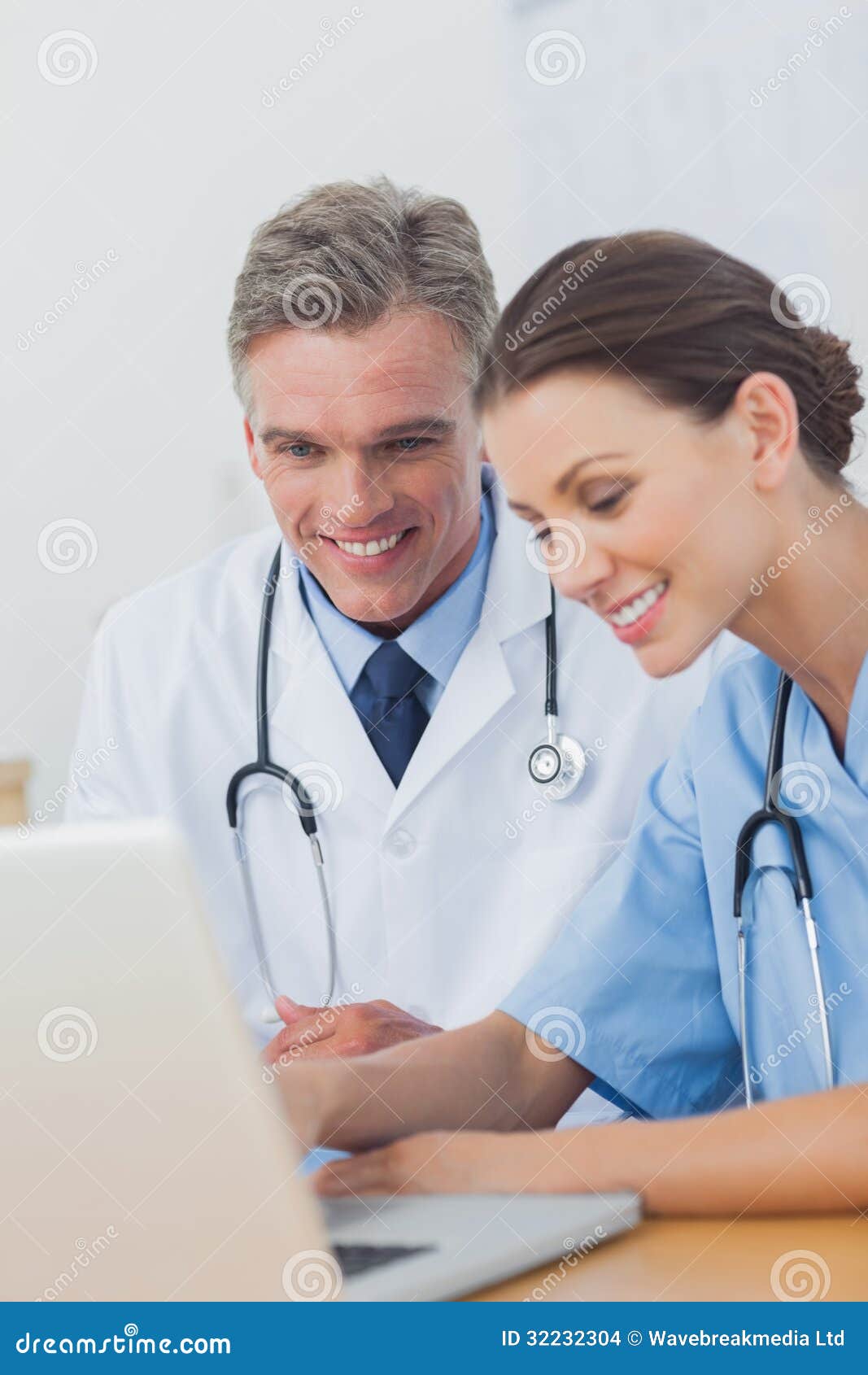 Two Cheerful Doctors Working on a Laptop Stock Photo - Image of looking ...