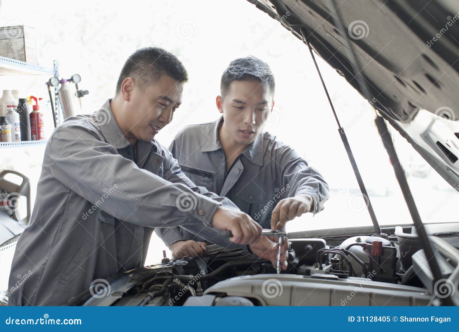 Two Cheerful Garage Mechanics Working on Engine Stock Image - Image of ...