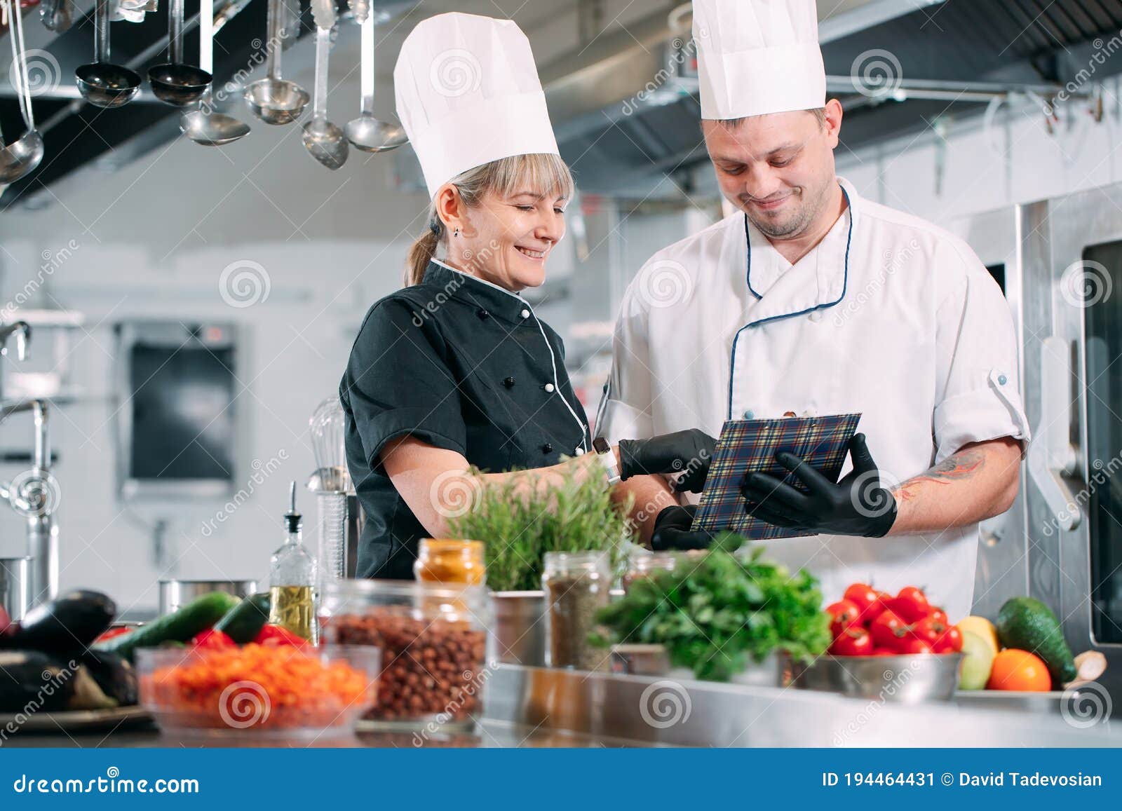 Two Chefs Discuss the Menu in the Kitchen of a Restaurant or Hotel ...