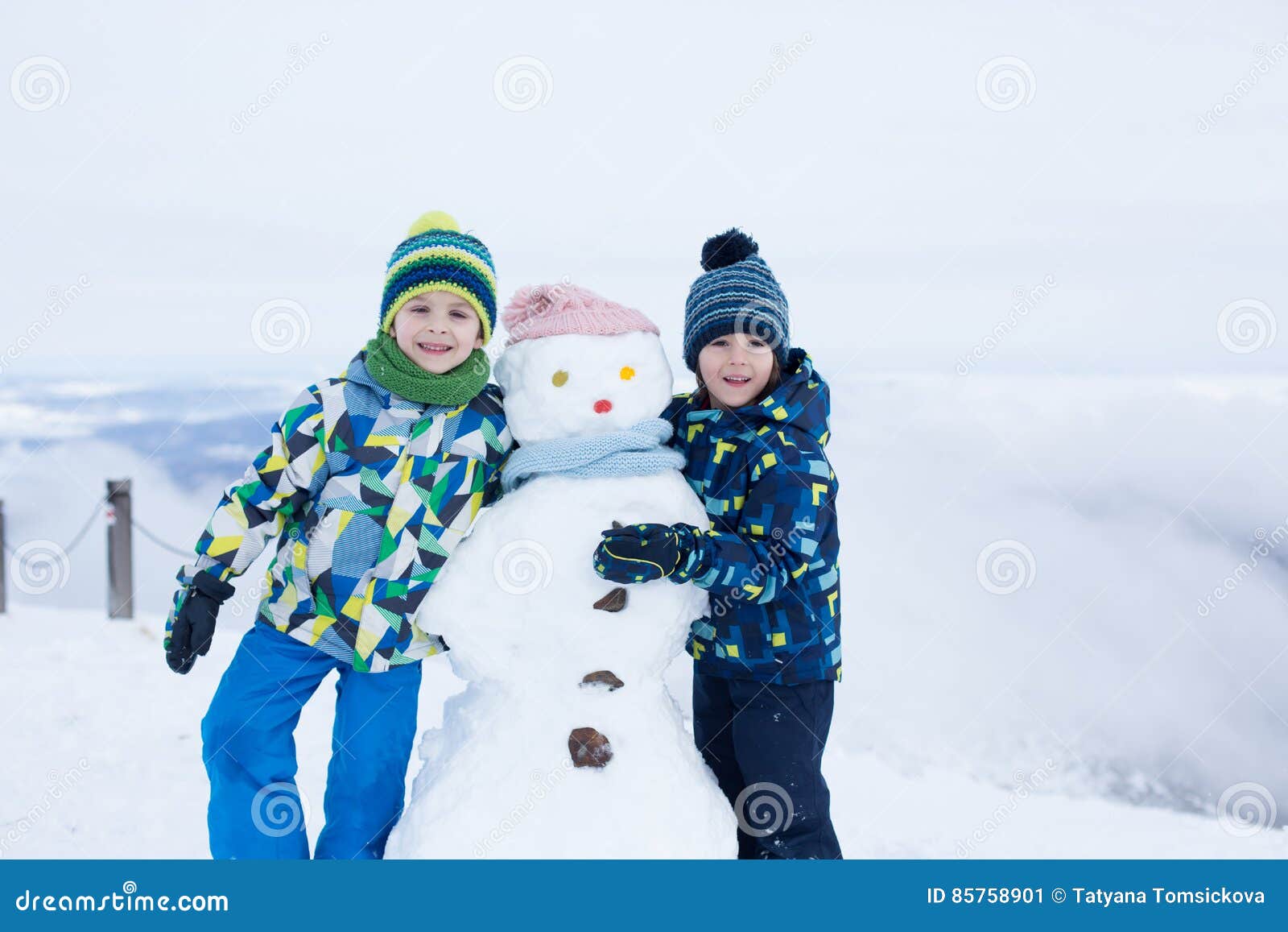 Two Children, Building Snowman on Top of Mountain Stock Image - Image ...