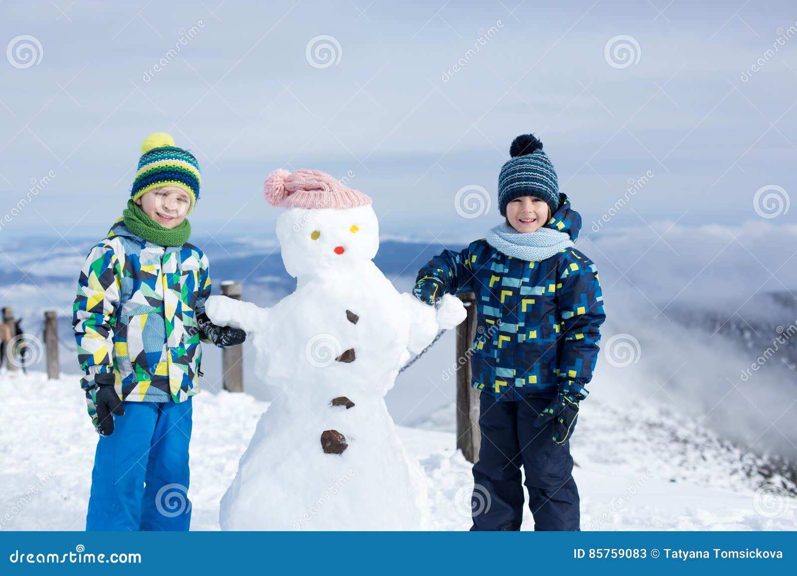 Two Children, Building Snowman on Top of Mountain Stock Image - Image ...