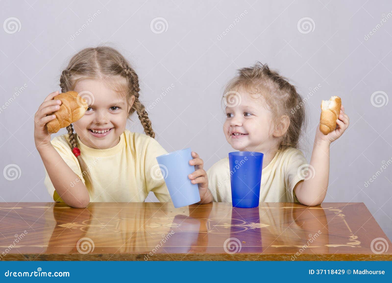 Two Children Eat a Muffin at the Table Stock Image - Image of four ...