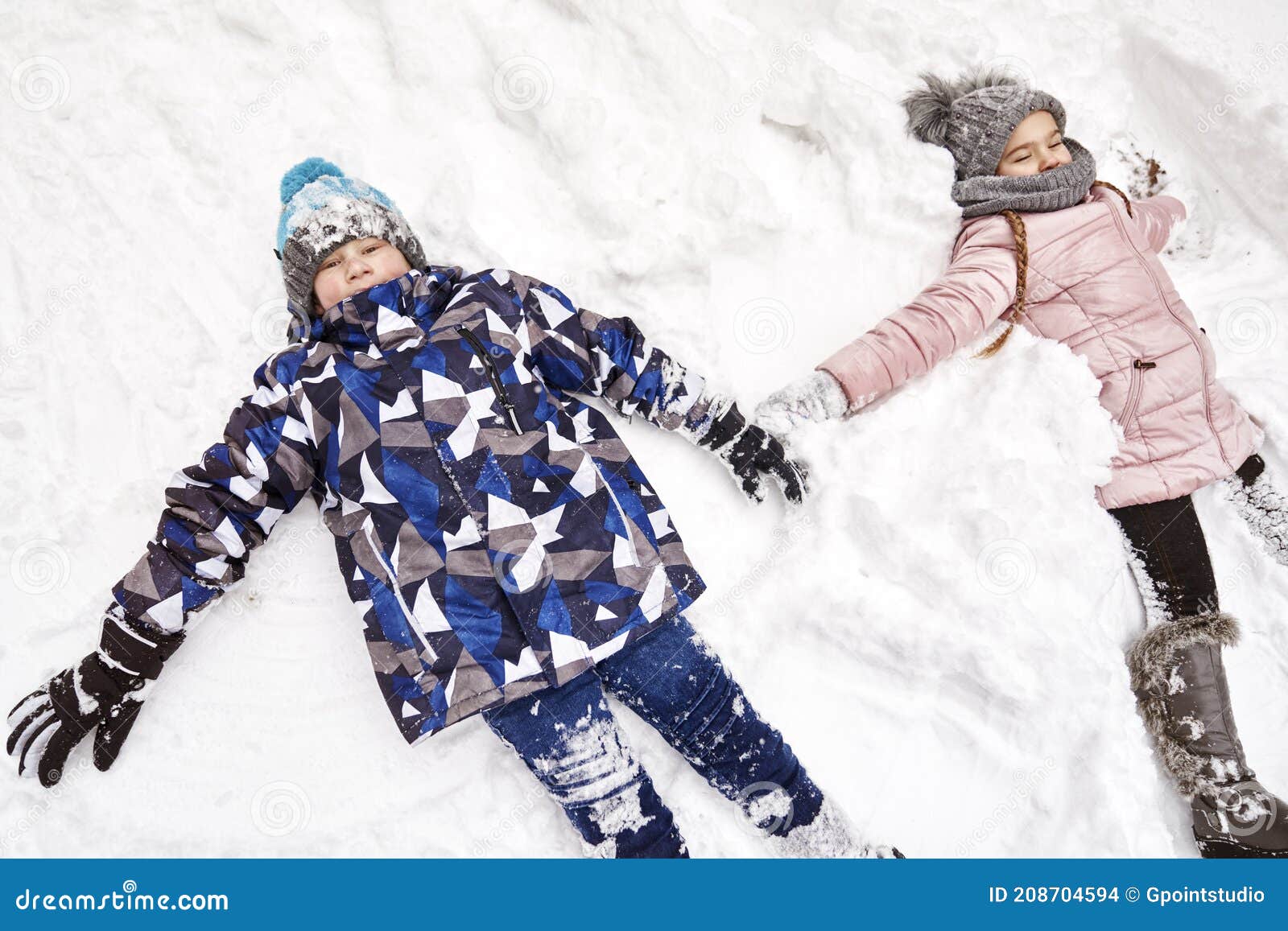 Two Children Making Snow Angels Stock Photo - Image of candid ...