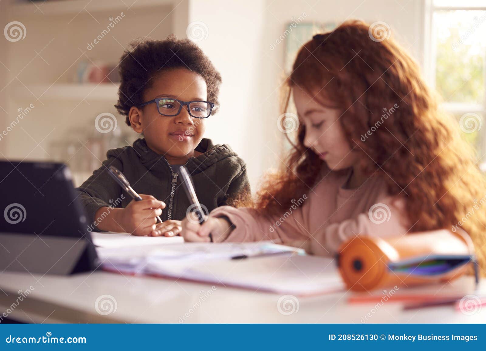 Two Children Sitting at Kitchen Counter Doing Homework Using Digital ...