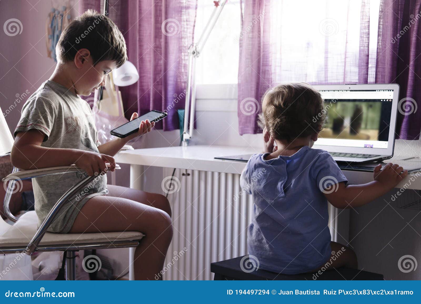 Two Children Watching Videos on Computer and Cell Phone Stock Photo ...