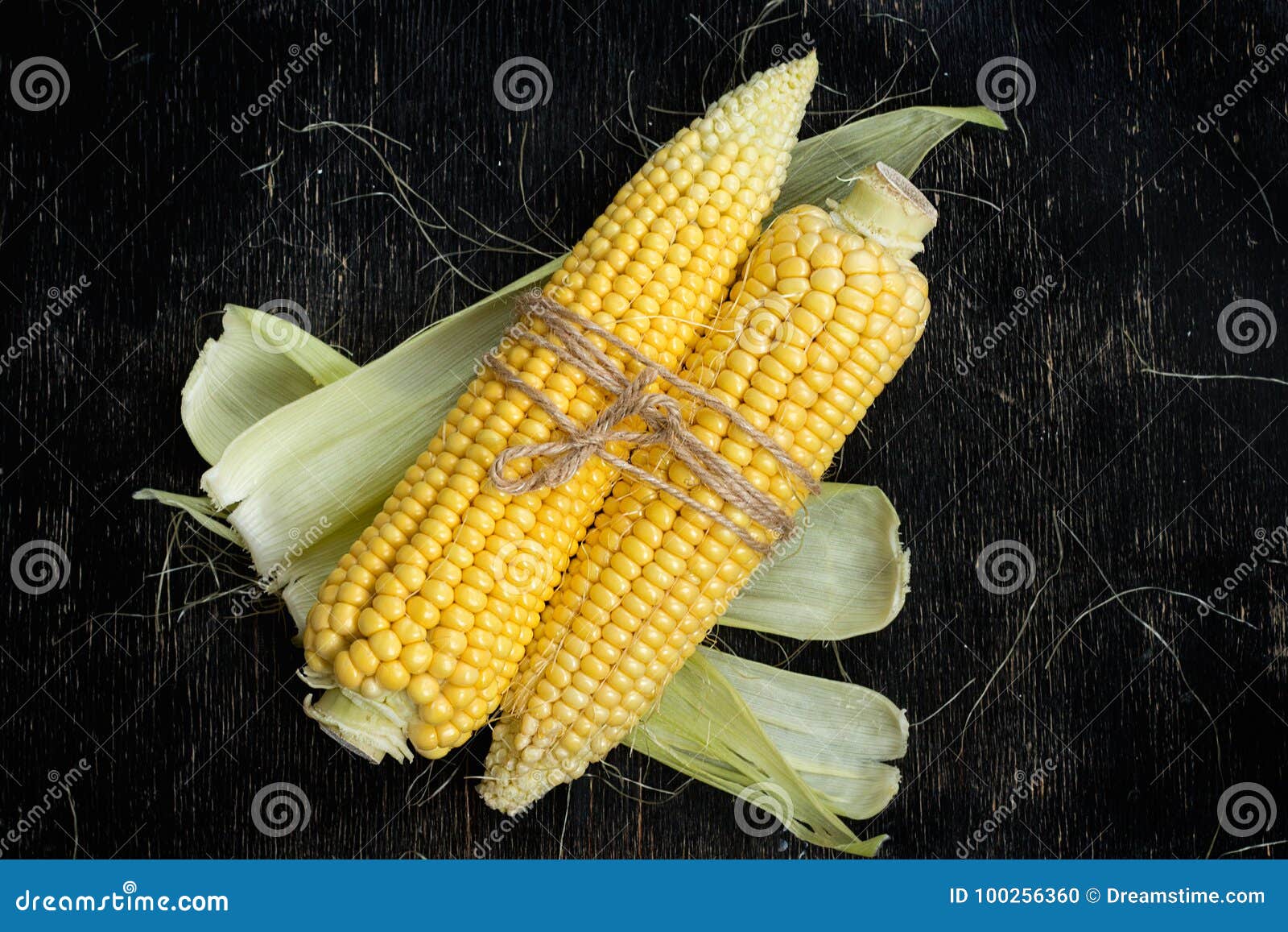 Two Cobs of Corn on a Black Wooden Table Stock Photo - Image of cobs ...