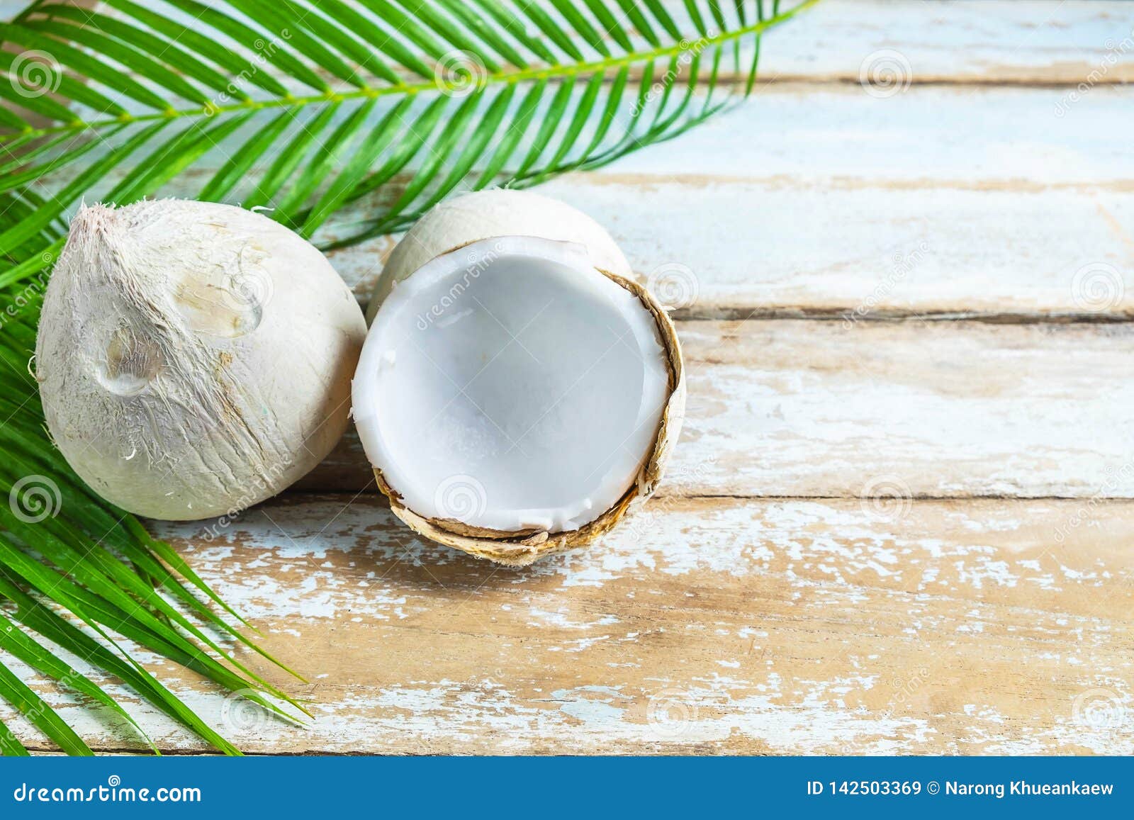 Two Coconut and Coconut Leaves on Wooden Table Stock Image - Image of ...