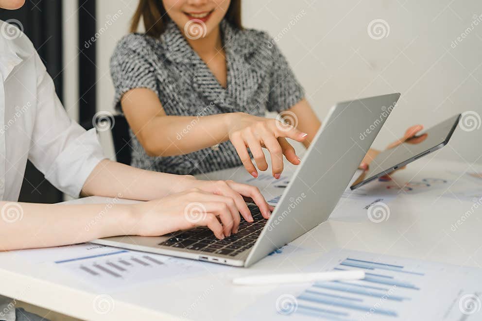 Two Colleagues Analyzing Financial Data Reports on Laptop with Charts and Graphs at Modern ...
