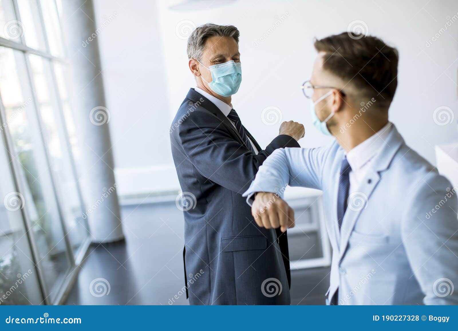 Two Colleagues Avoid a Handshake when Meeting in the Office and Greet ...