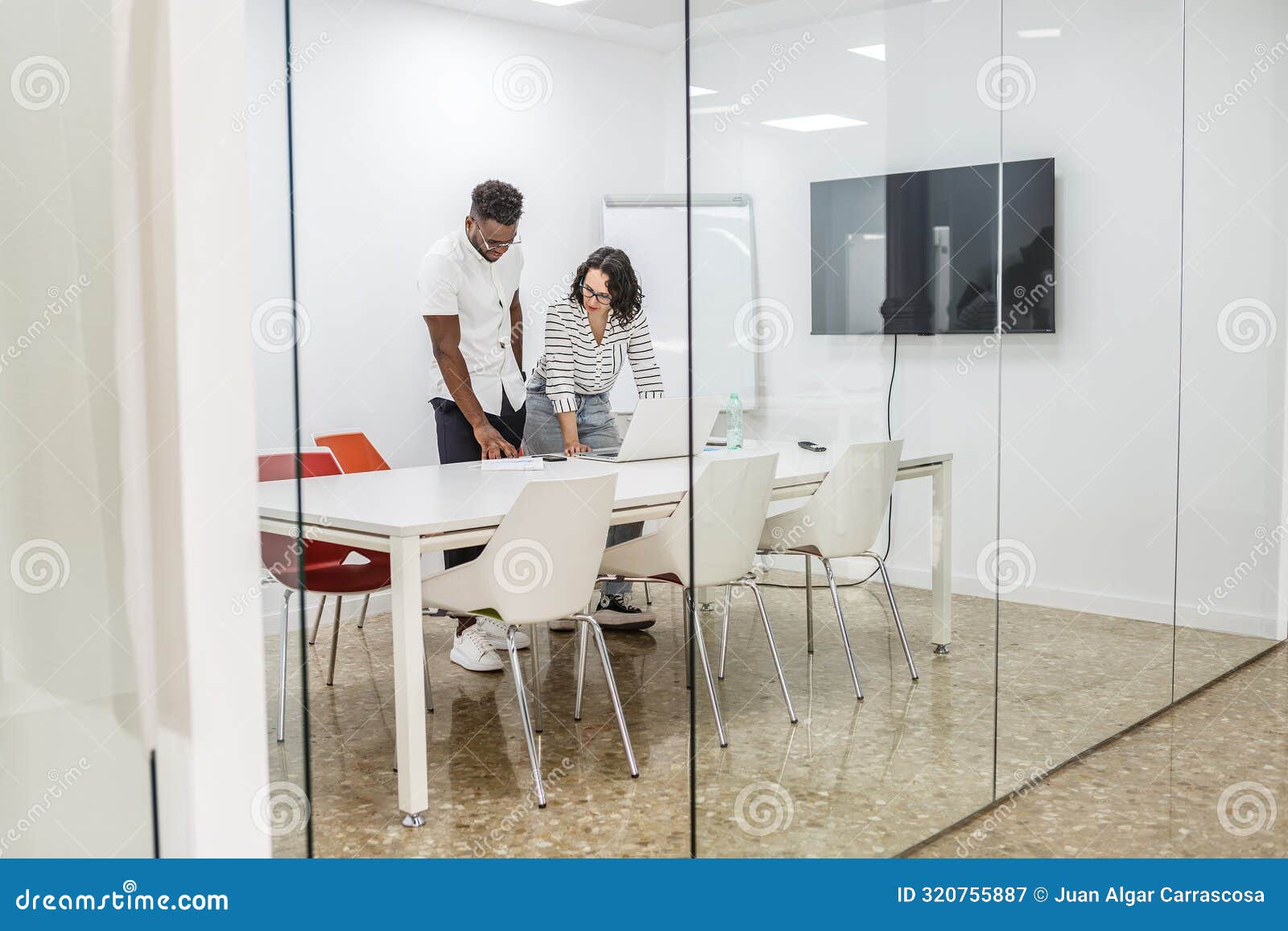 Two Colleagues Collaborate on a Laptop in a Modern Office Space Stock ...