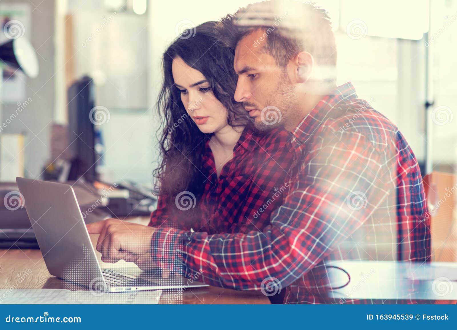 Two Colleagues Discussing Work on a Laptop. Stock Image - Image of ...