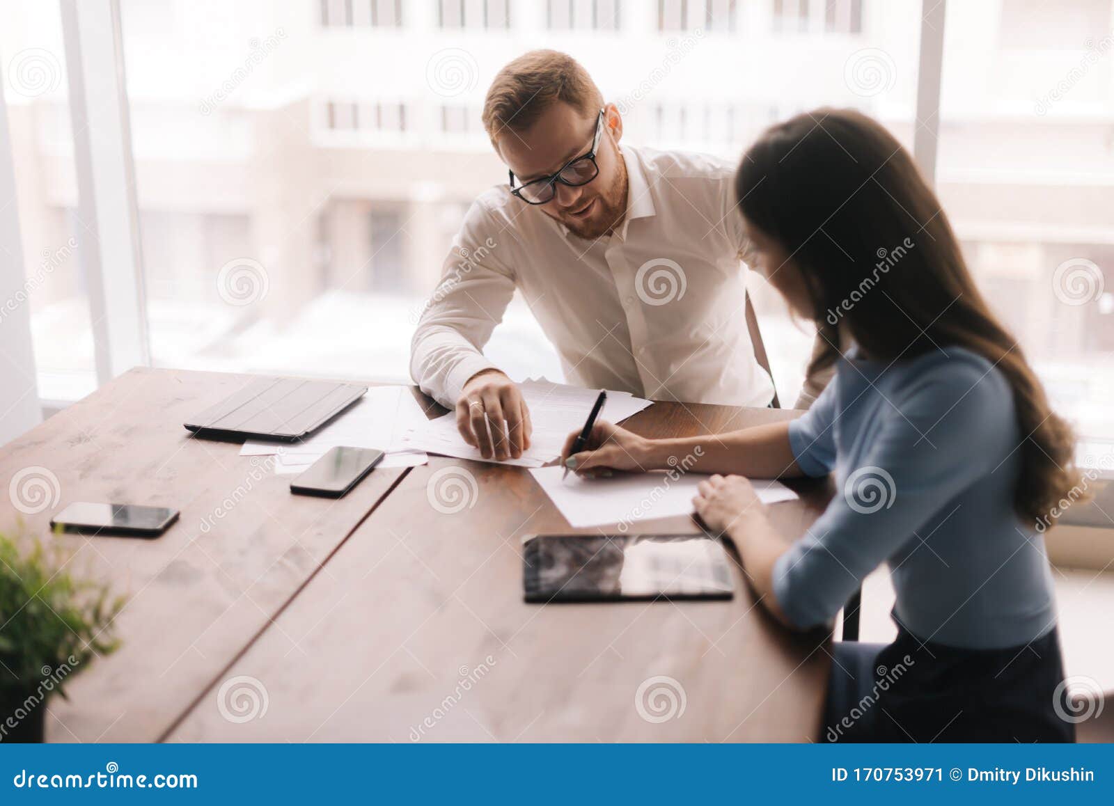 Two Colleagues Employees Man and Woman are Cooperating in Boardroom ... Two Colleagues Employees Man and Woman are Cooperating in Boardroom ...