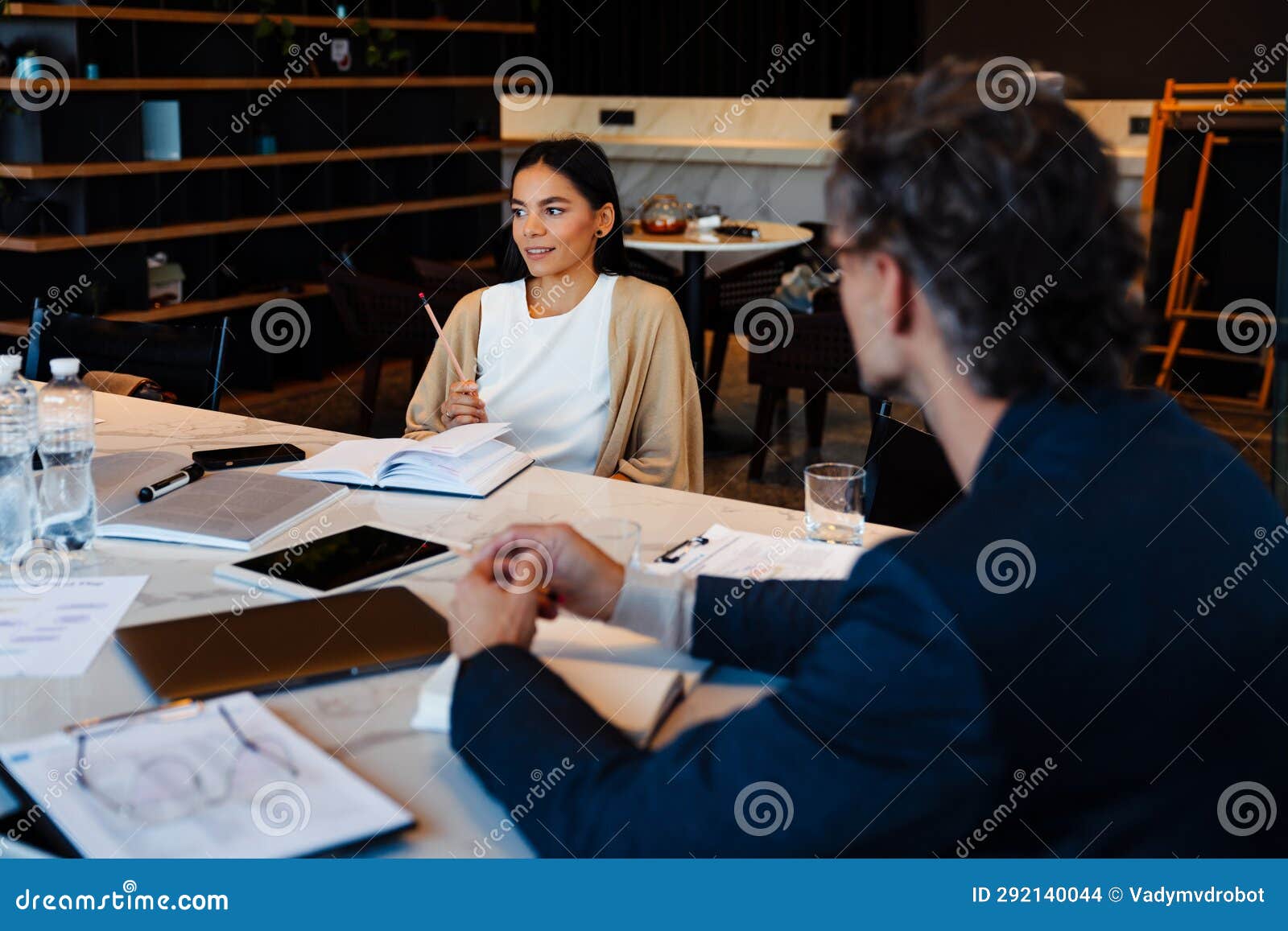 Two Colleagues Talking while Sitting at Table in Office Stock Photo ...