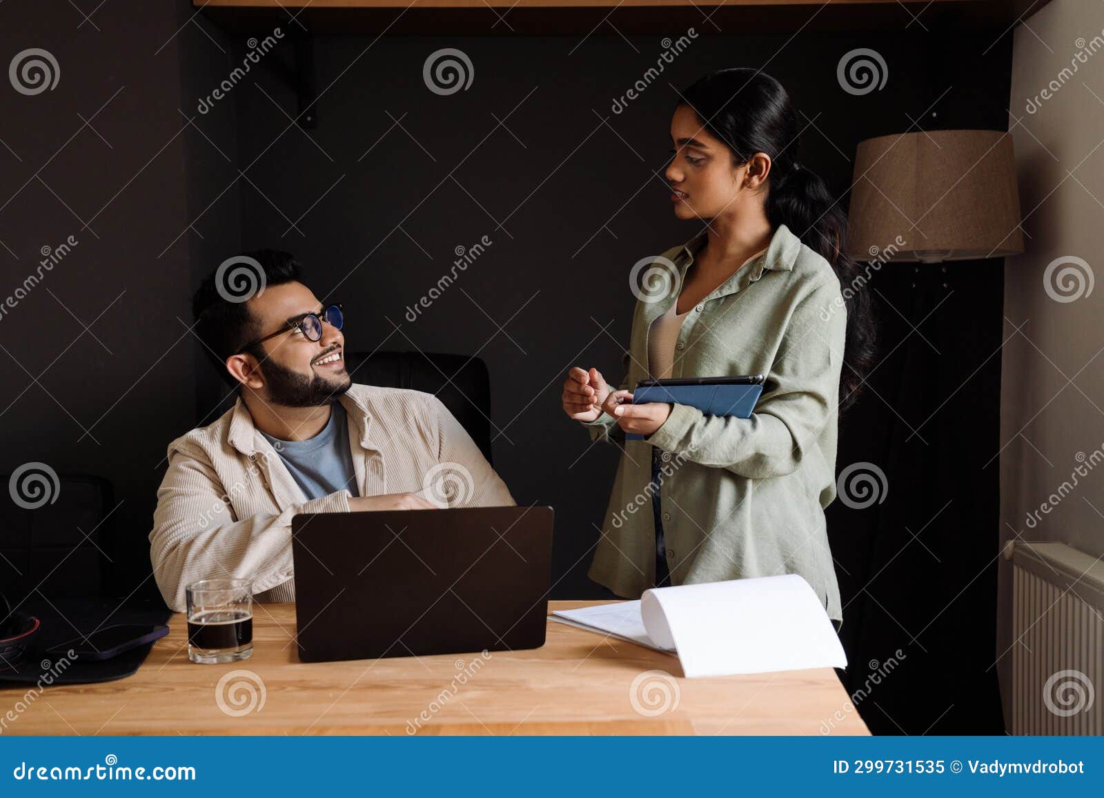 Two Colleagues Using Laptop Computer and Tablet while Working Together ...
