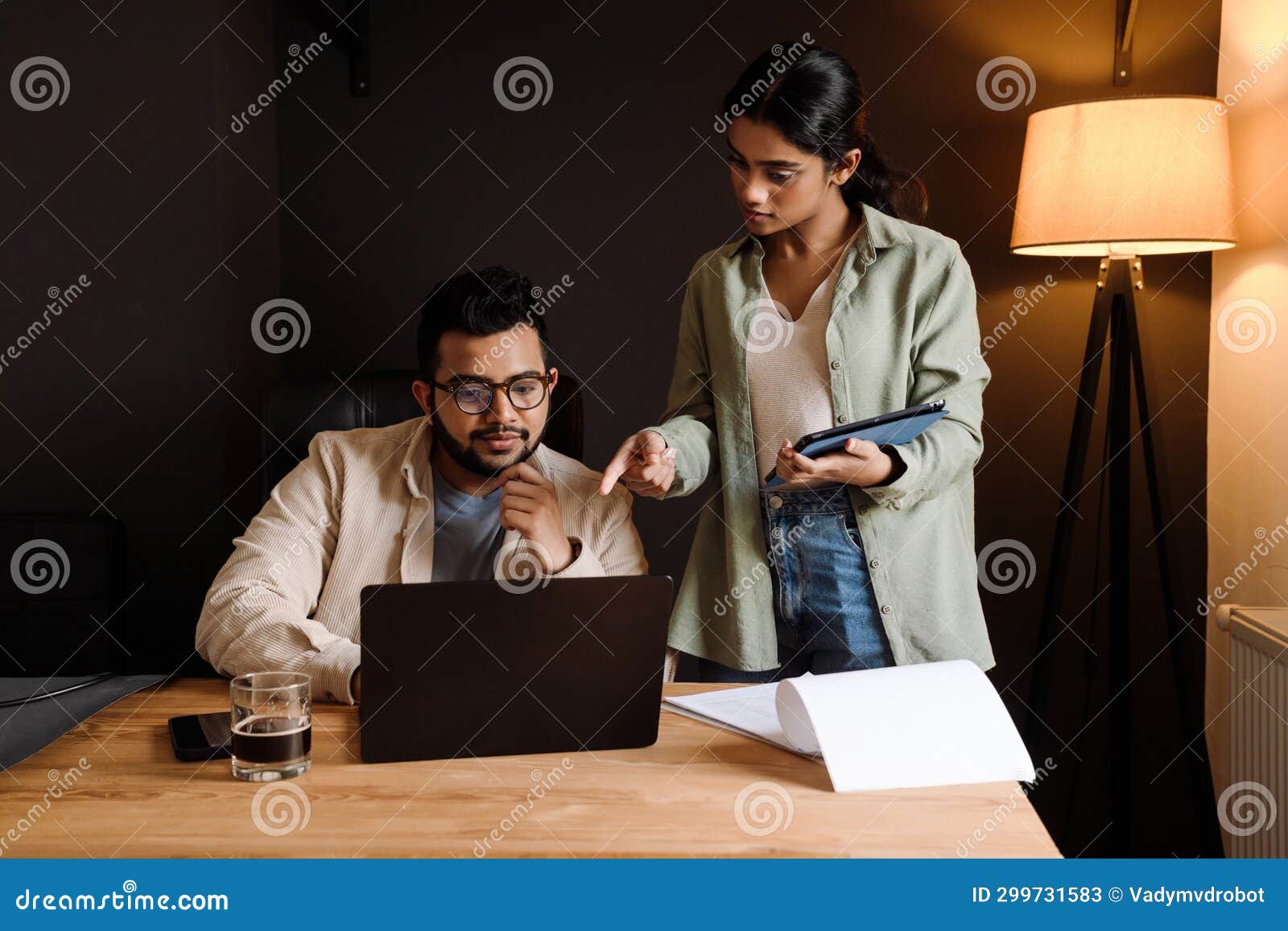Two Colleagues Using Laptop Computer and Tablet while Working Together ...