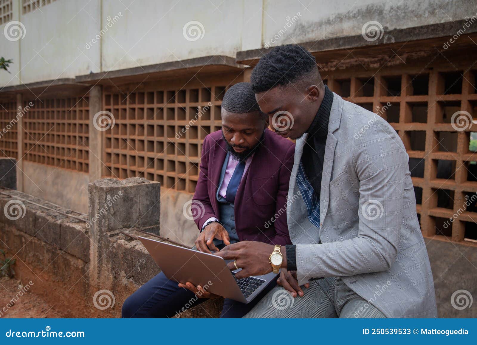 Two Colleagues Working an a Project Together Look at a Laptop Screen ...
