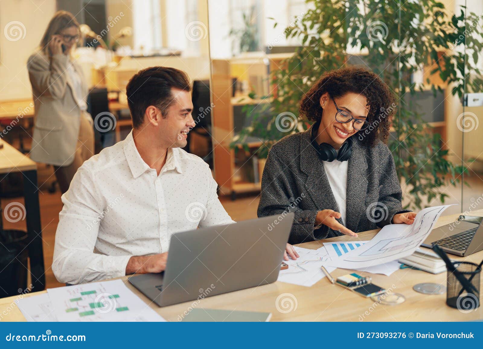 Two Colleagues Working Together with Documents while Sitting on Office ...