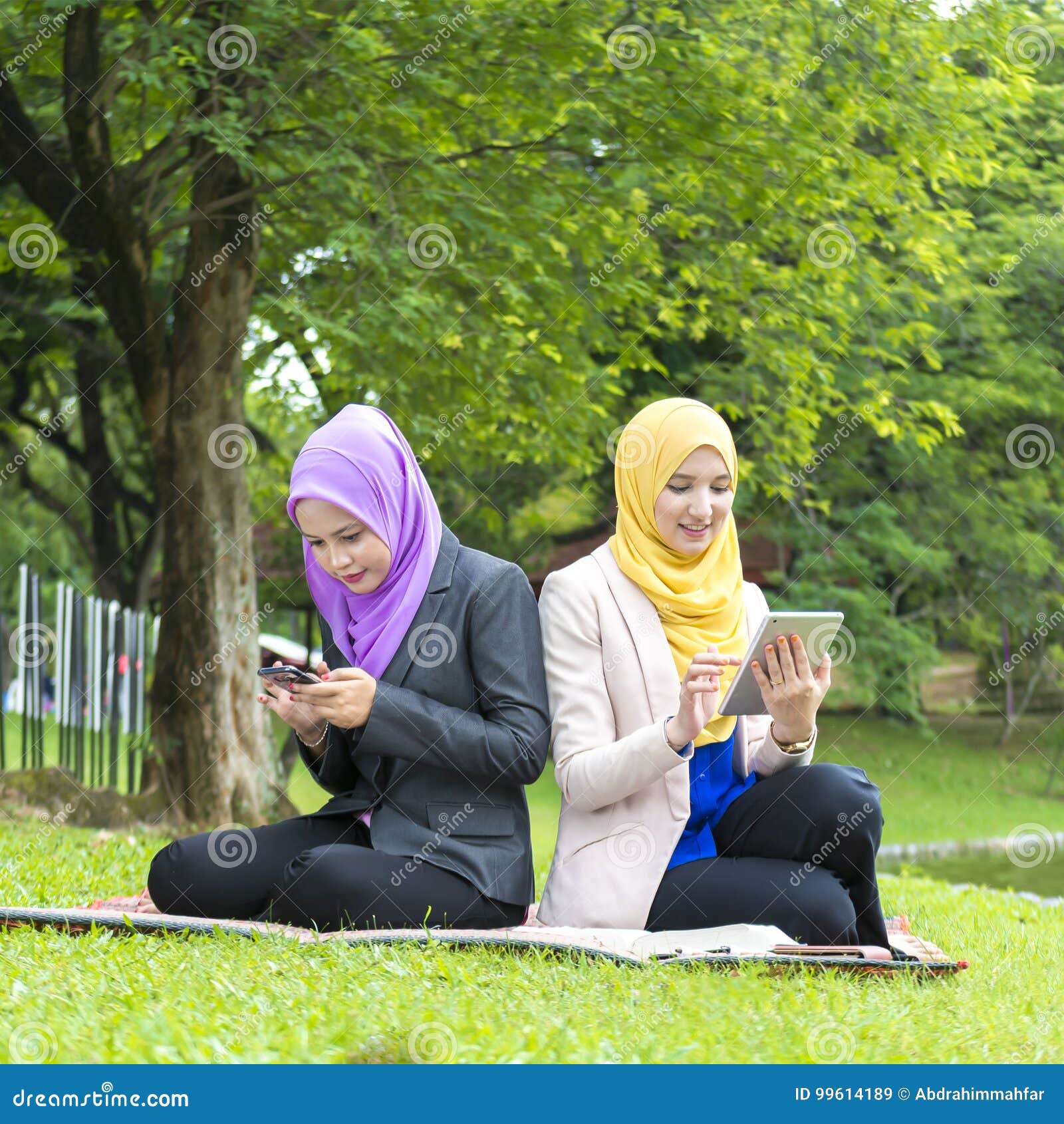 Two College Students Busy Texting with Their Smartphone while Resting ...