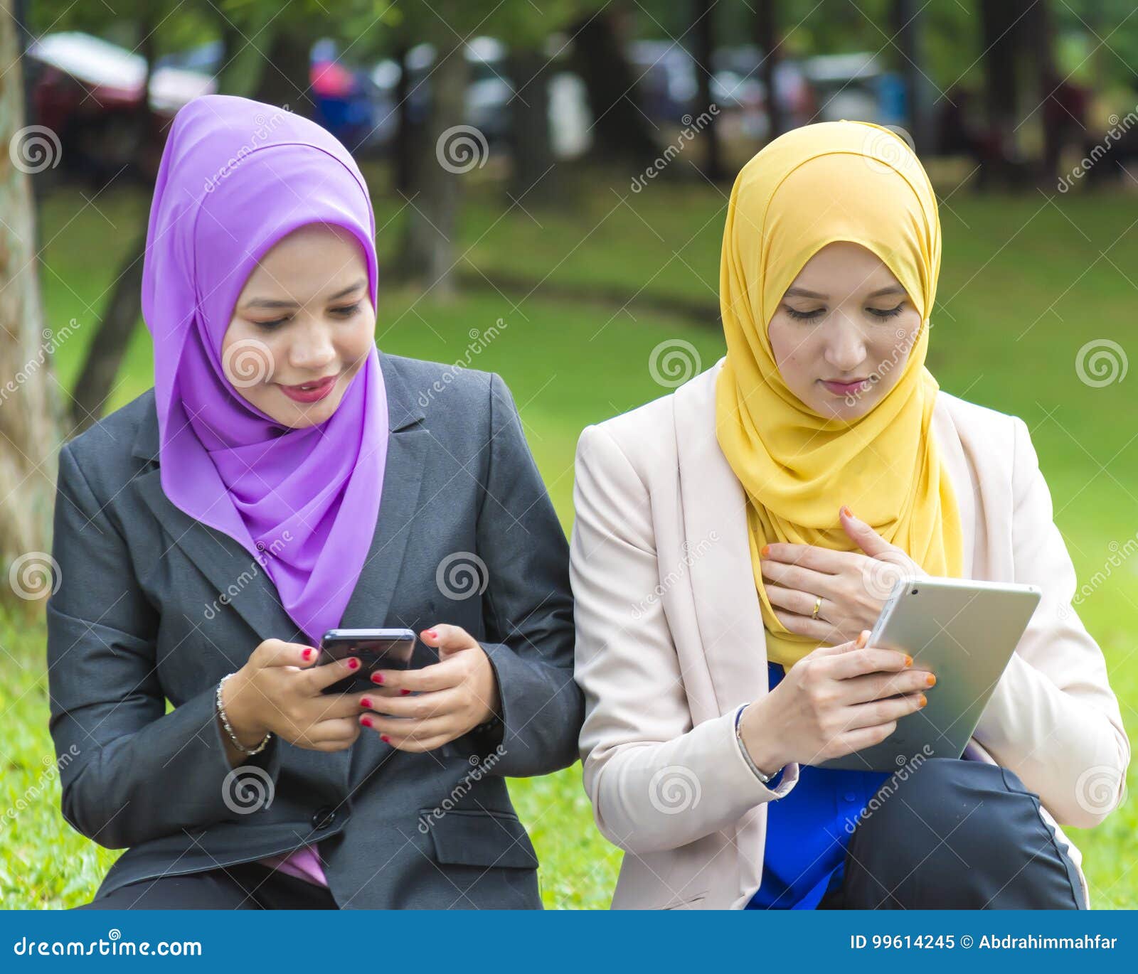 Two College Students Busy Texting with Their Smartphone while Resting ...