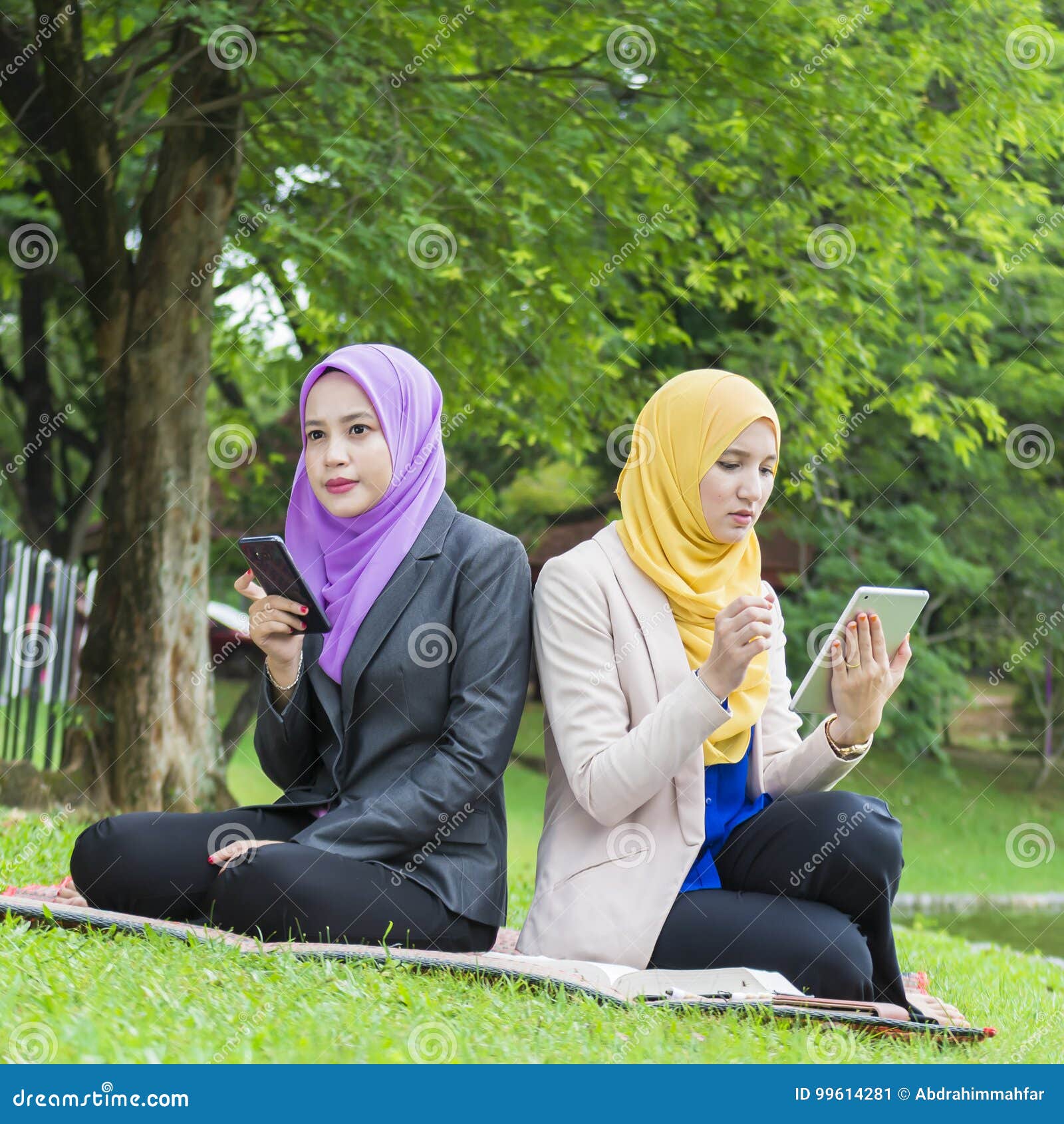 Two College Students Busy Texting with Their Smartphone while Resting ...