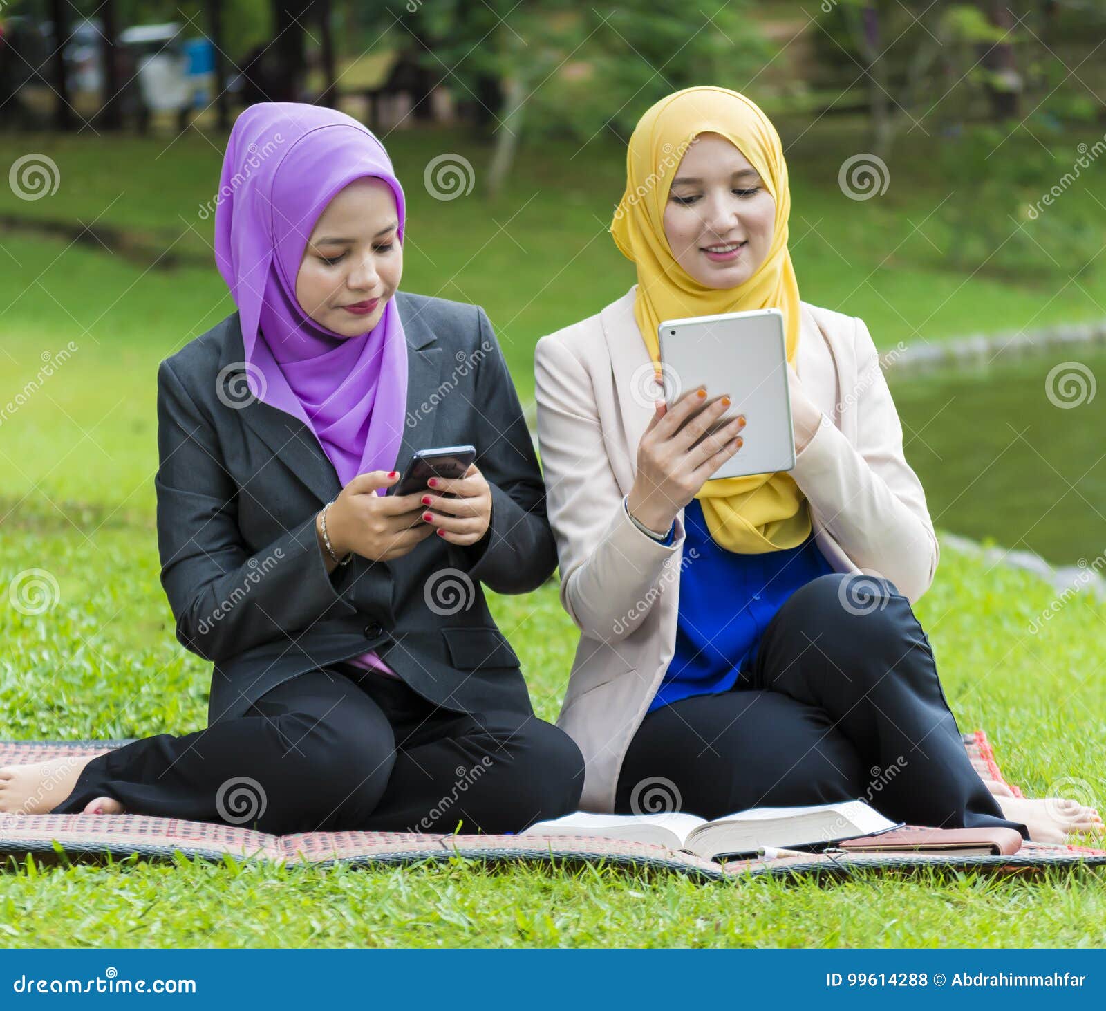 Two College Students Busy Texting with Their Smartphone while Resting ...