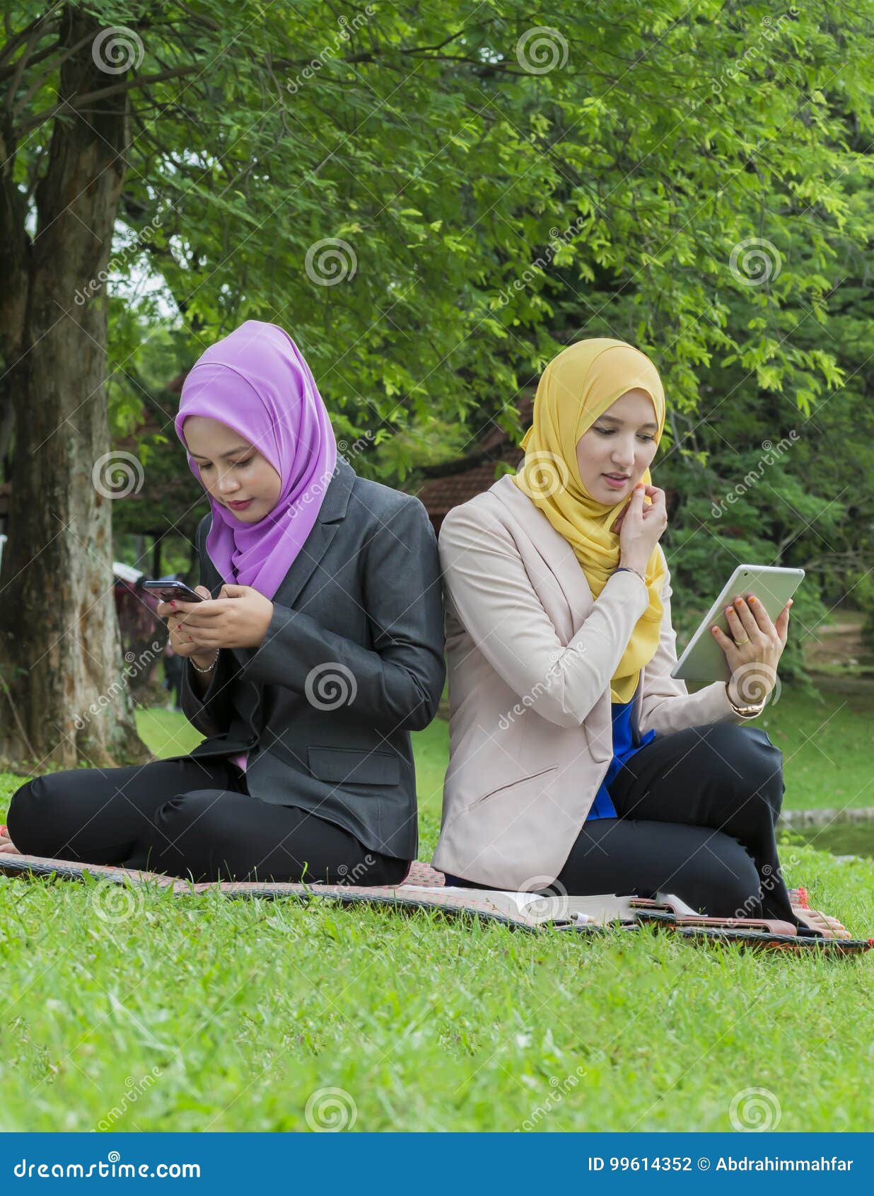 Two College Students Busy Texting with Their Smartphone while Resting ...