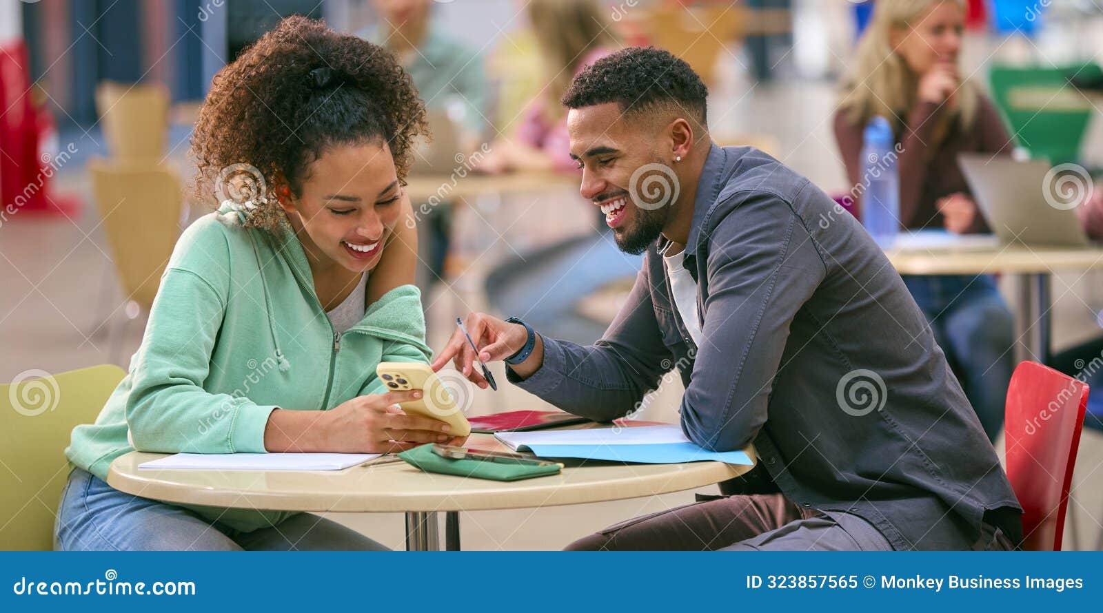 Two College or University Students with Mobile Phone Working Together ...