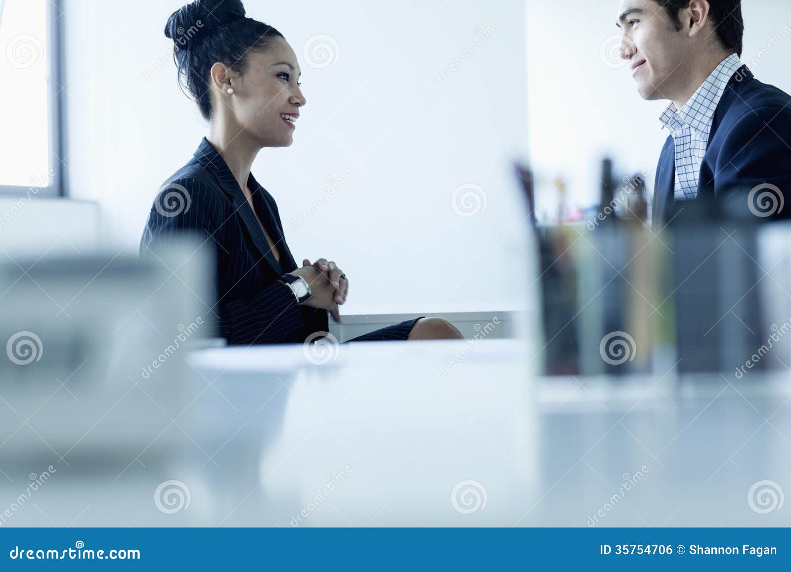 Two Colleges Smiling and Talking by the Desk in the Office Stock Photo ...