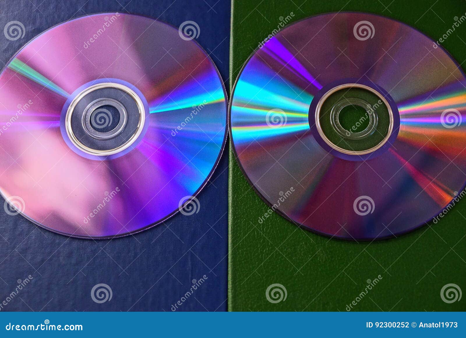Two Compact Discs on a Blue Green Surface Stock Photo - Image of ...