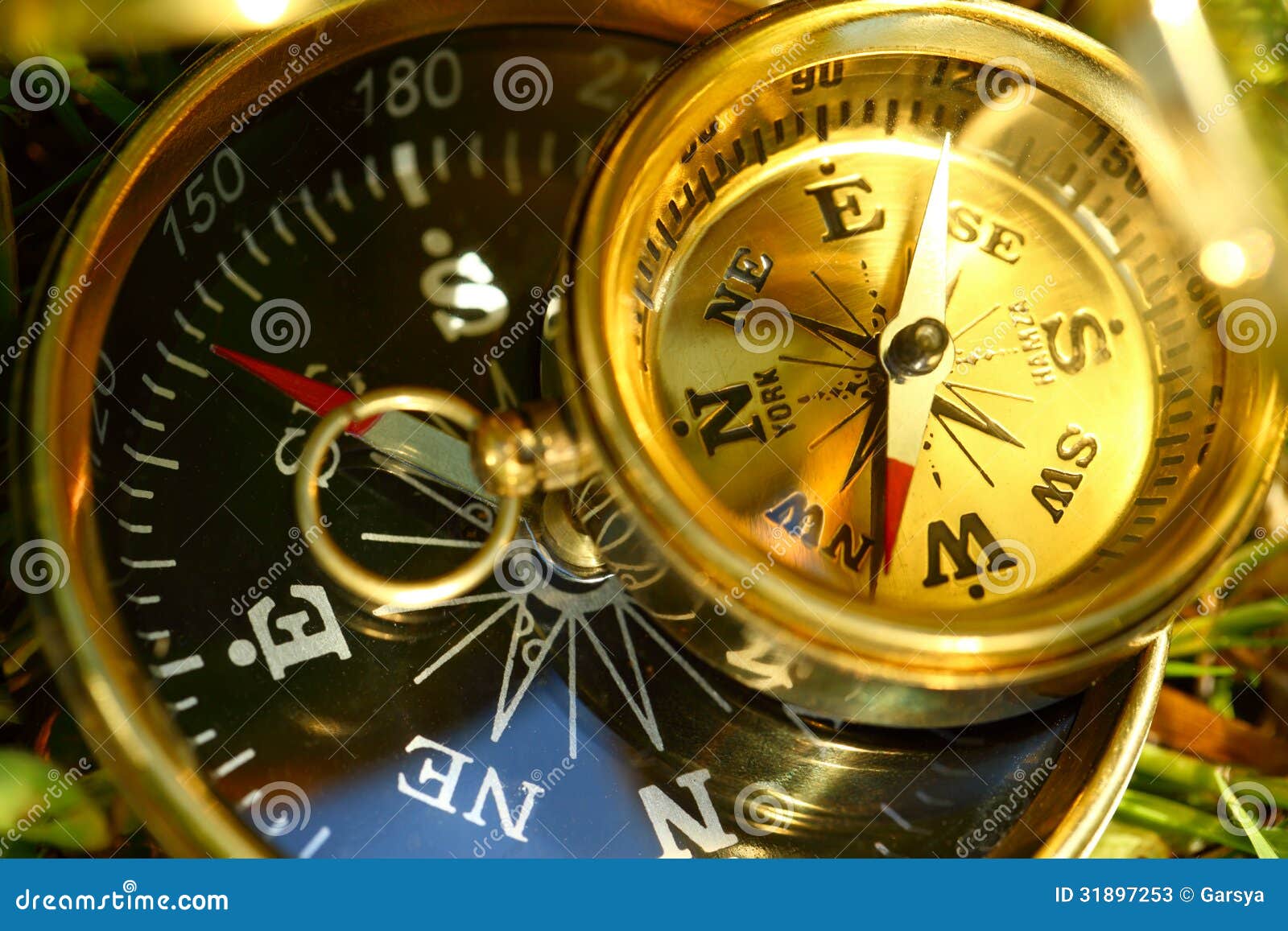 Two compasses on grass stock image. Image of land, arrow - 31897253
