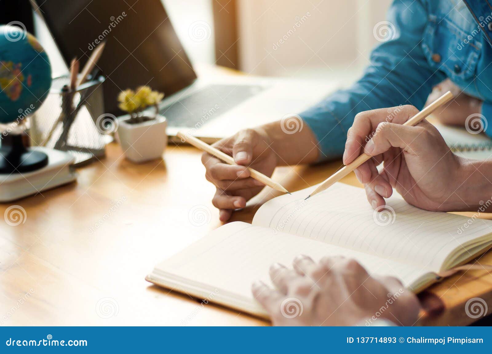 Two Confident Students Doing Homework Together while Sitting at the ...